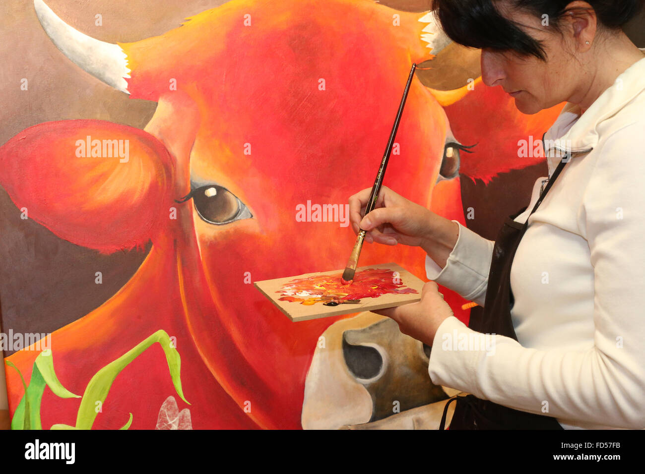 French artist Muriel Mollier Pierret painting in her gallery Stock ...