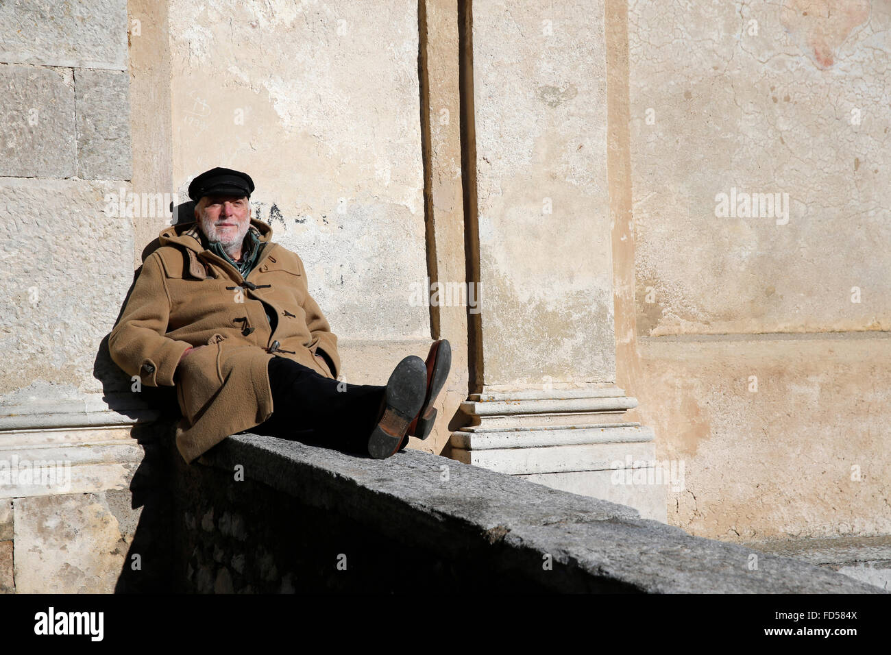 Elderly man resting on a wall Stock Photo - Alamy
