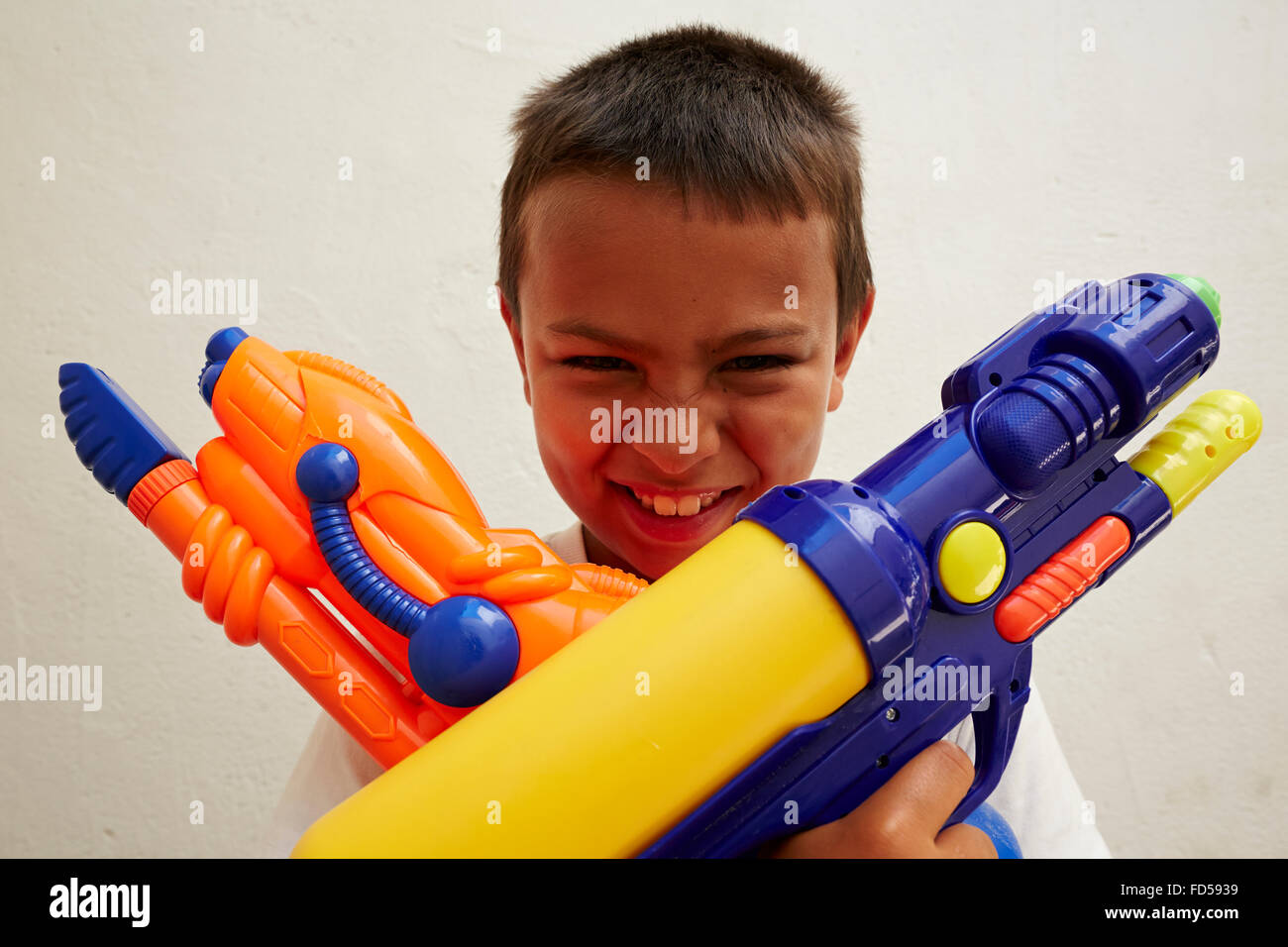 Boy carrying toy guns Stock Photo - Alamy