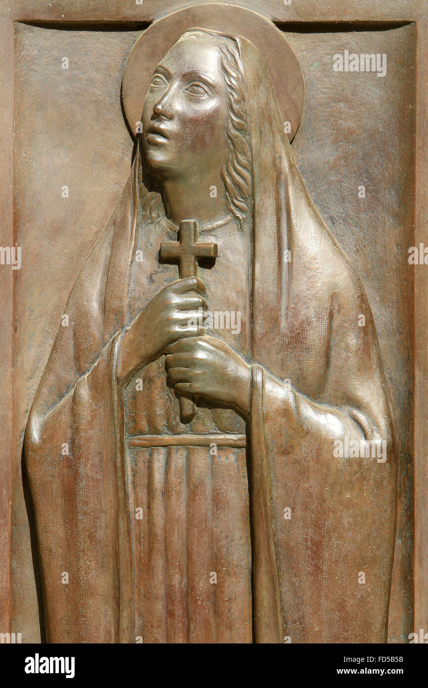 Saint holding a cross in her hands Stock Photo - Alamy