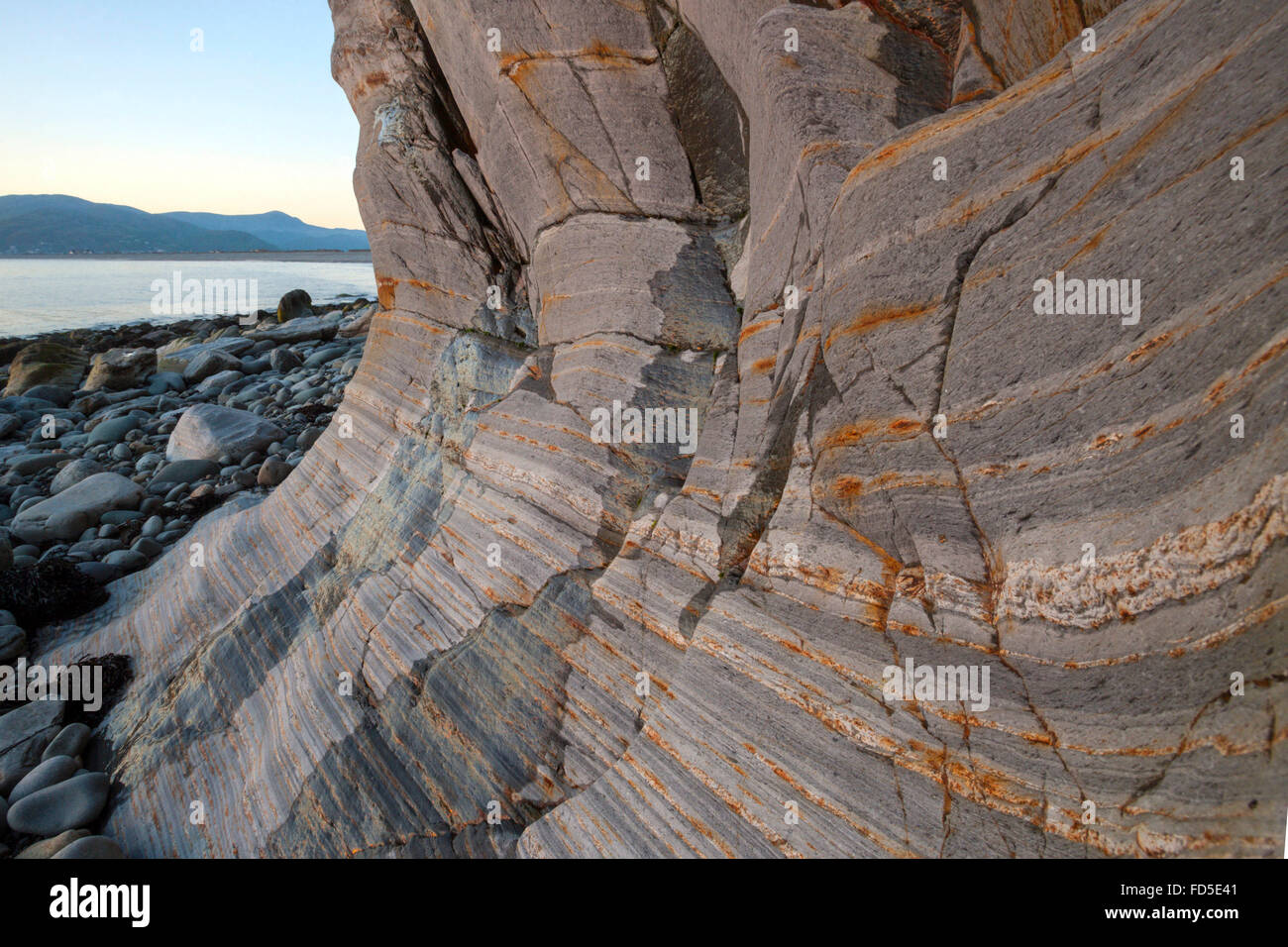 small and large rocks are at the base of the cliffs that rise upon the ...