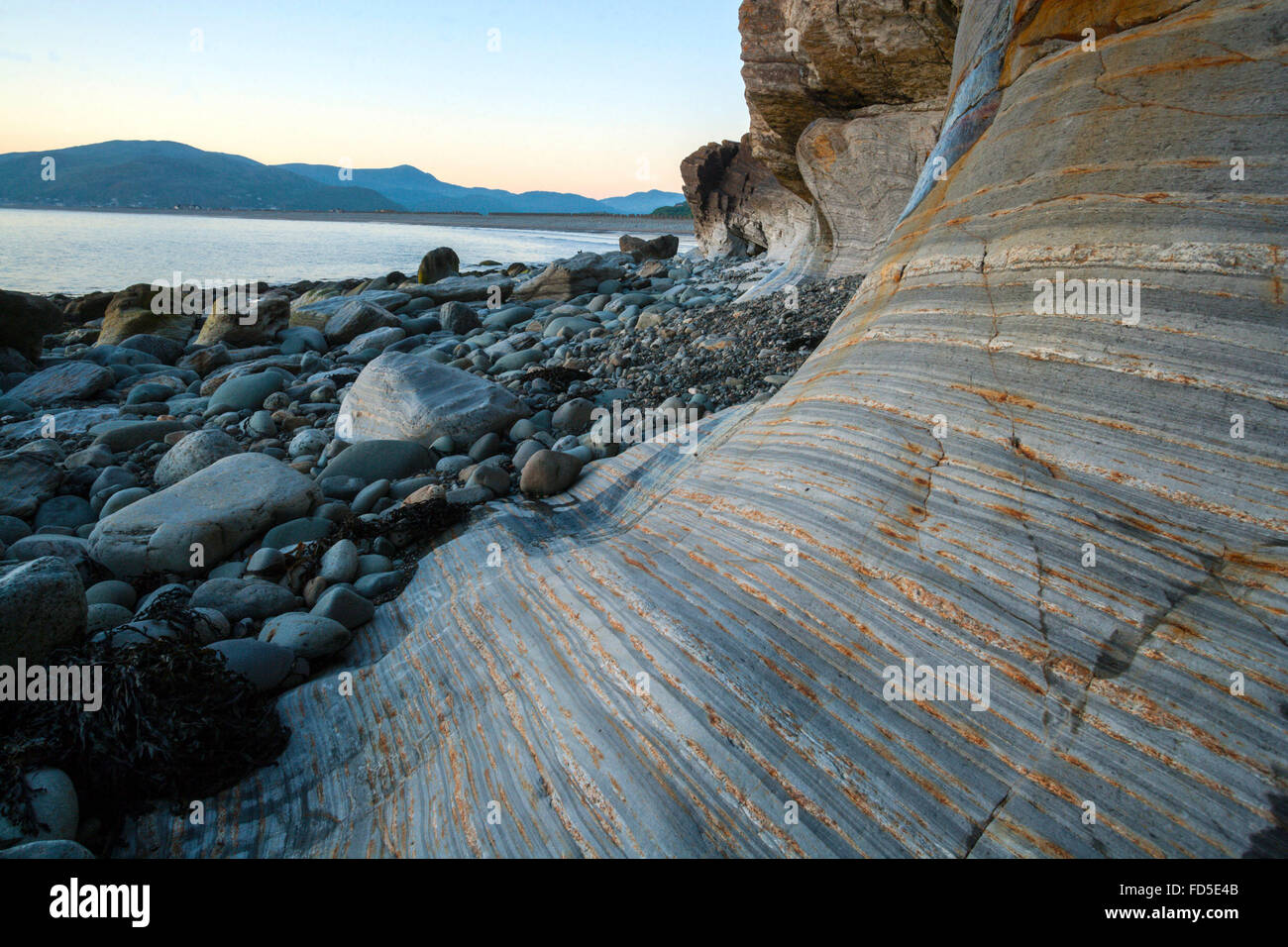 small and large rocks are at the base of the cliffs that rise upon the ...