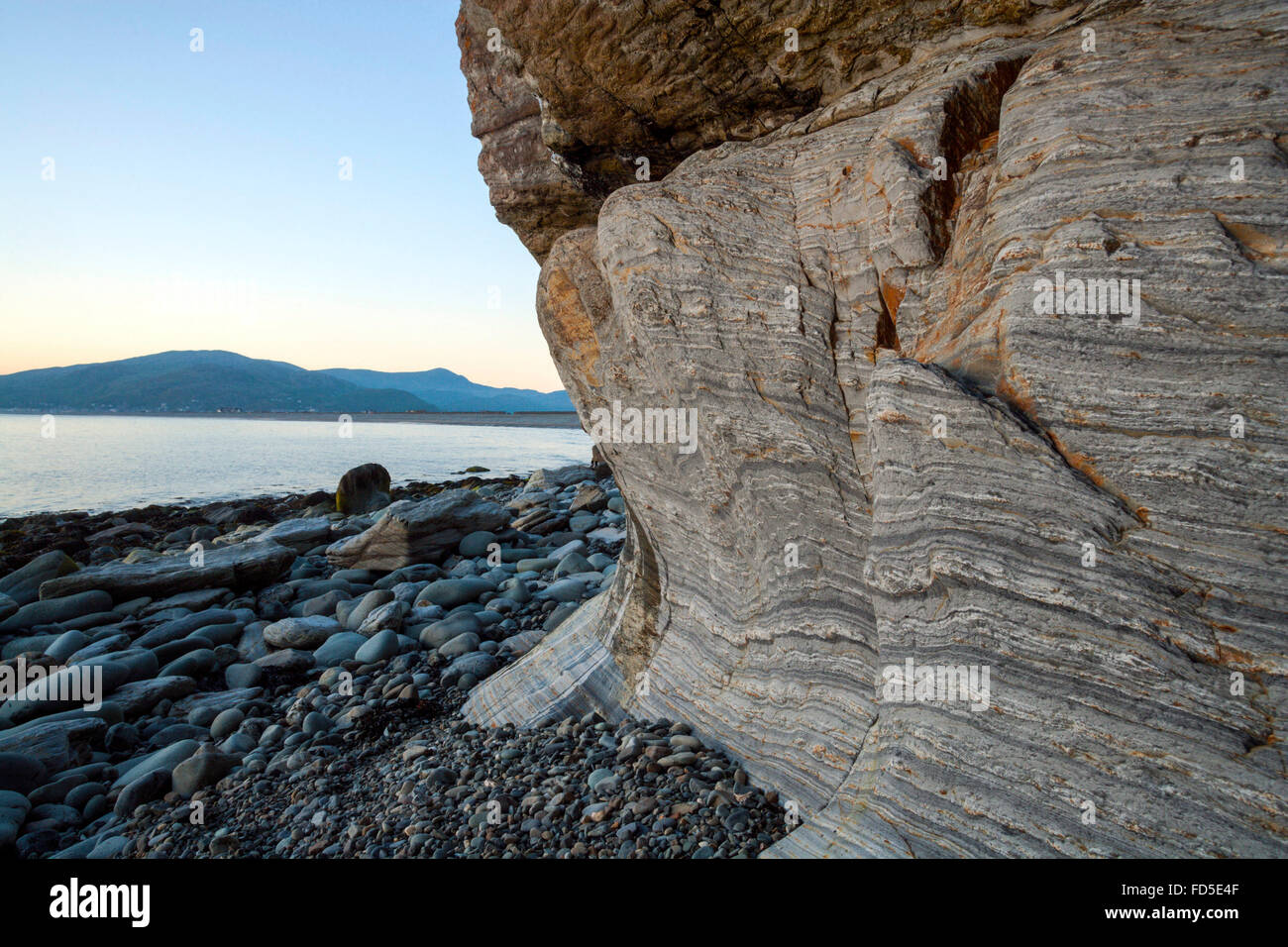small and large rocks are at the base of the cliffs that rise upon the ...