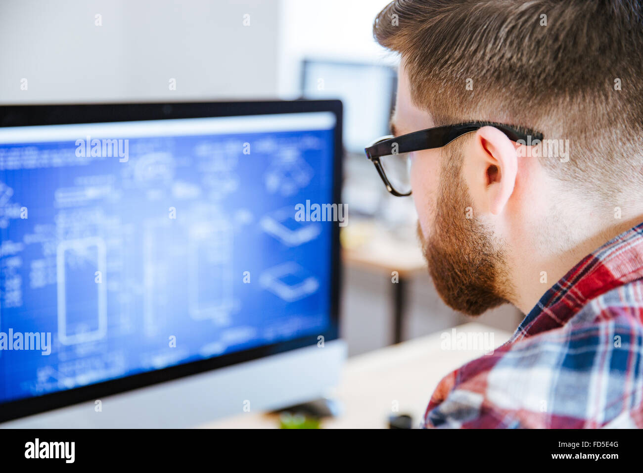 Closeup of young man in glasses with beard making blueprints on ...