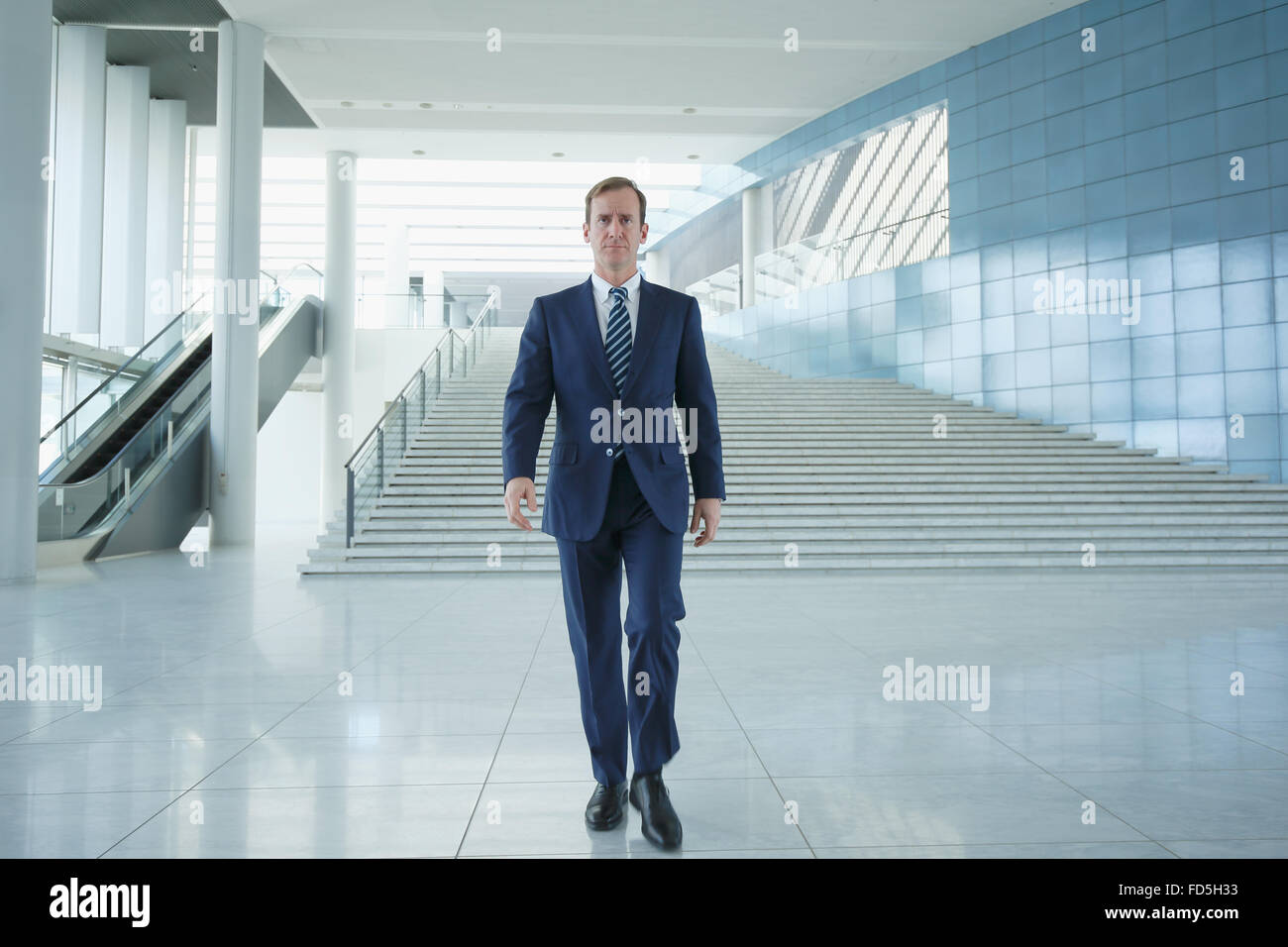 Businessman walking in office building hi-res stock photography and ...