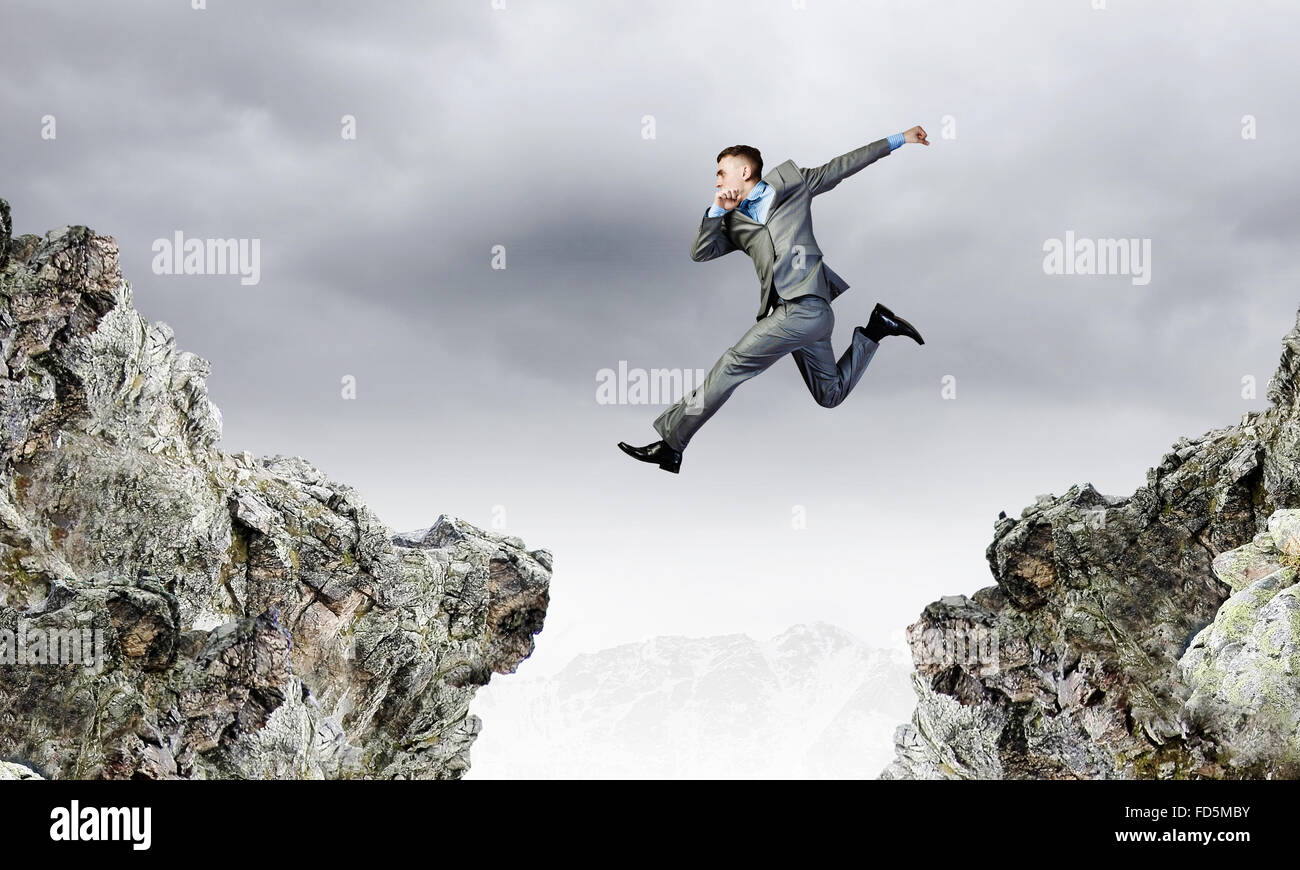 Image of young businessman jumping over gap Stock Photo - Alamy
