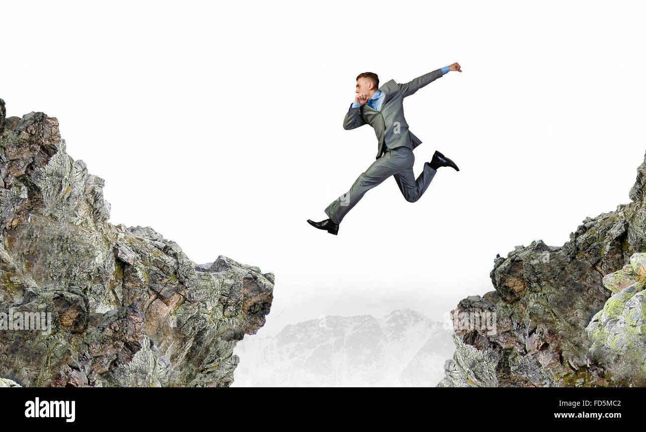 Image of young businessman jumping over gap Stock Photo - Alamy