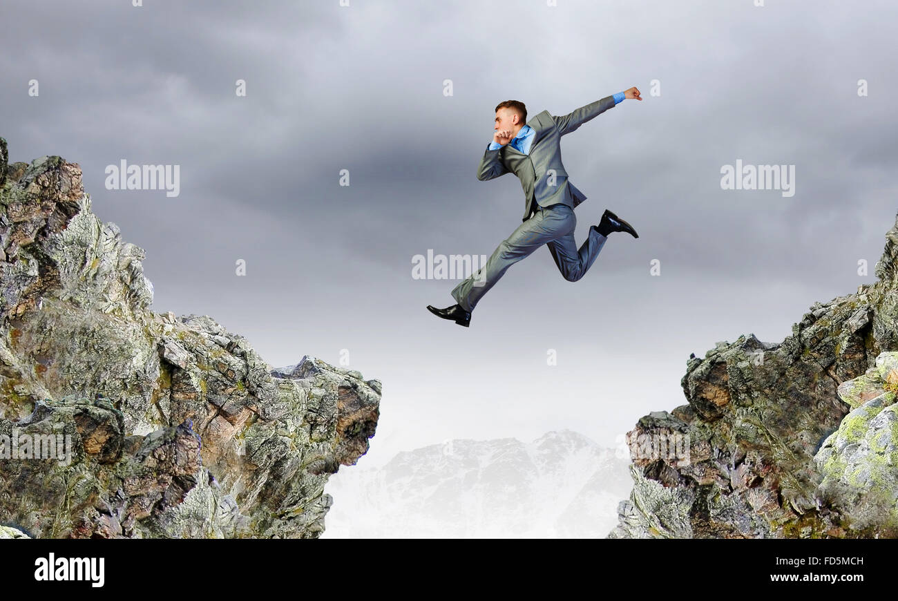 Image of young businessman jumping over gap Stock Photo - Alamy