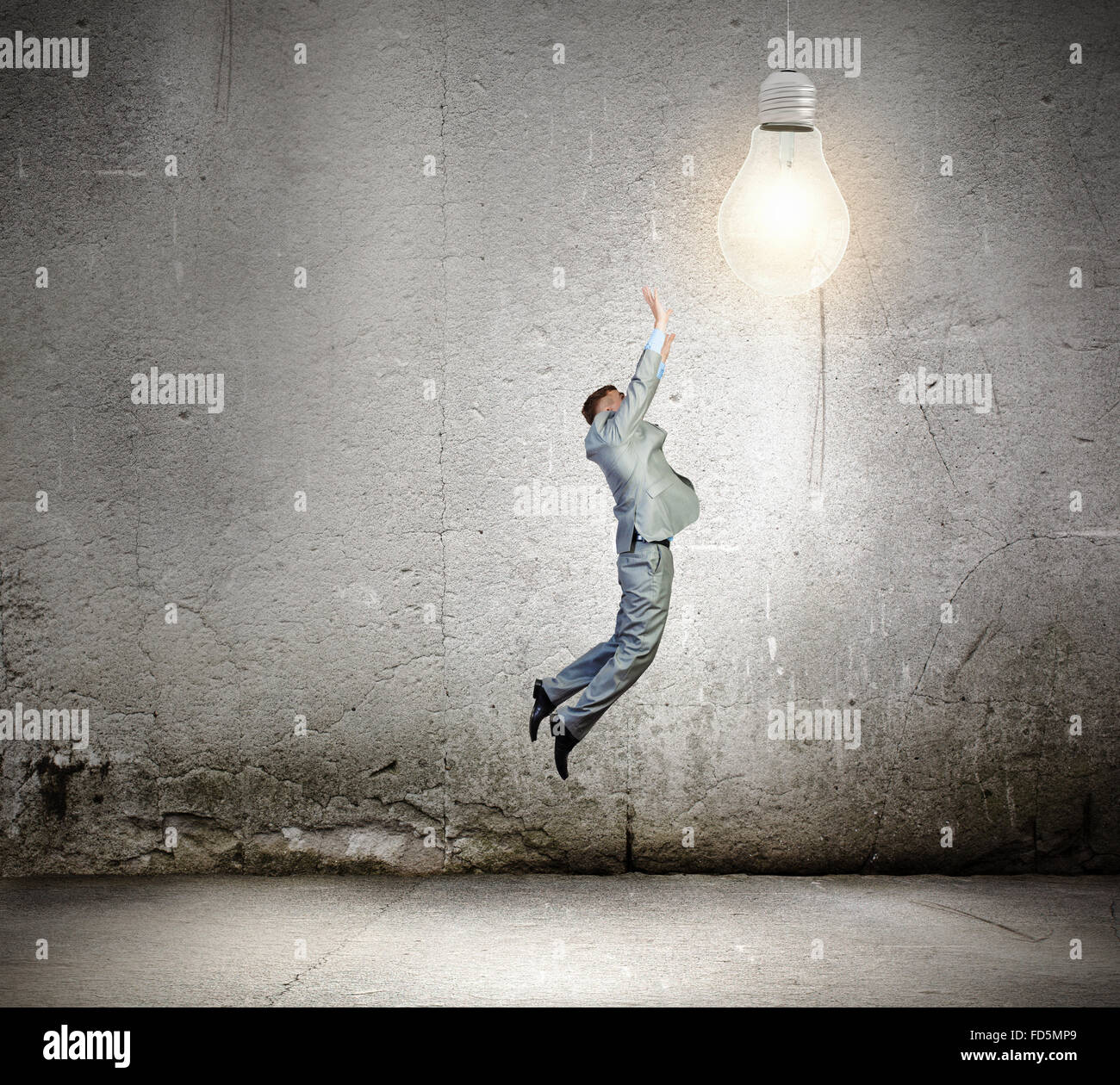 Image of businessman jumping to catch light bulb Stock Photo - Alamy