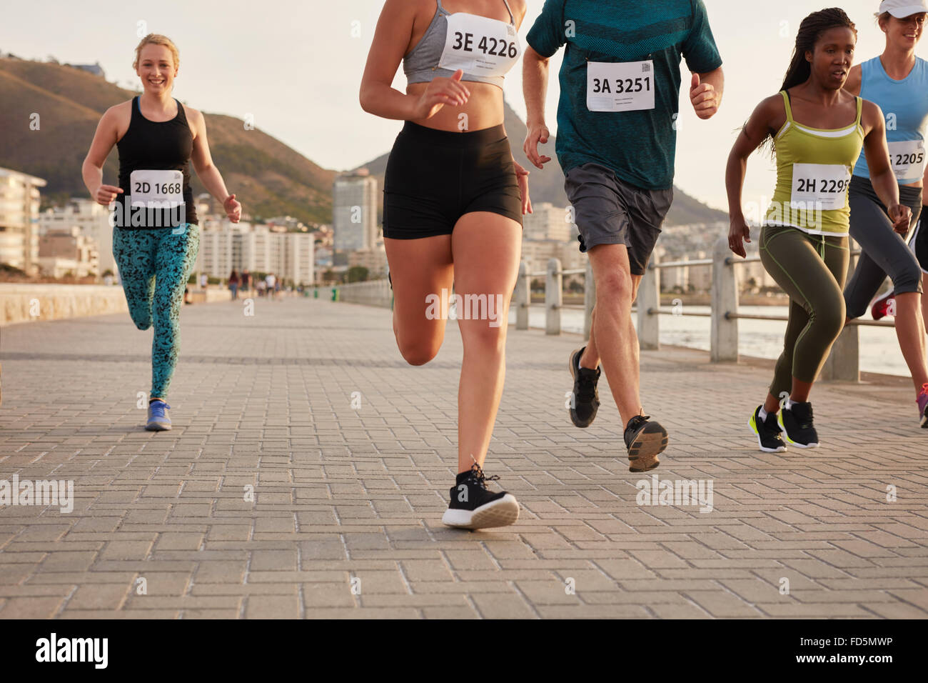 Diverse group of runners competing in a race. Athletes sprinting on a ...