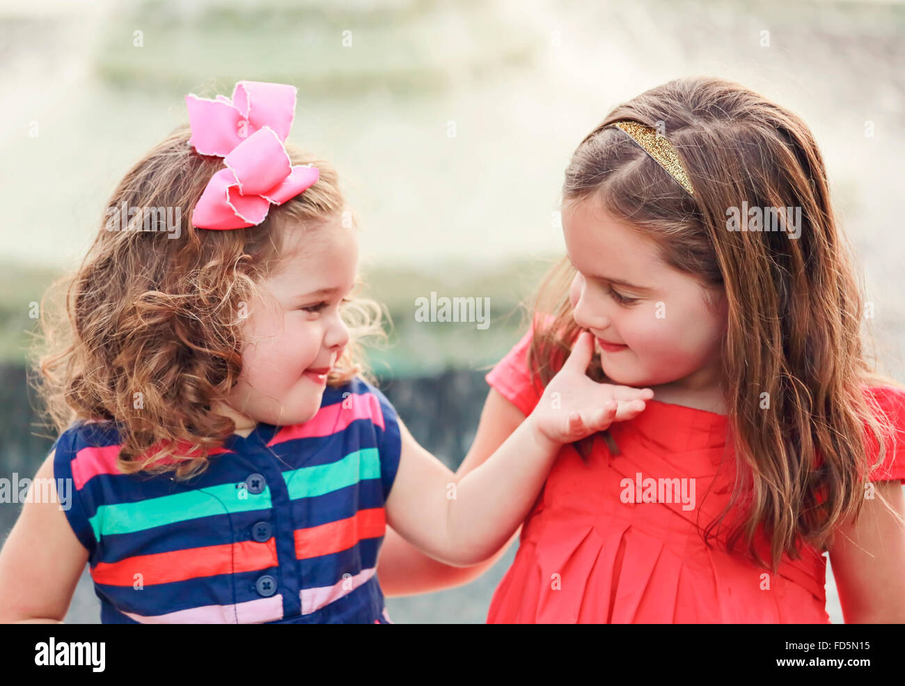Two sisters smiling sweetly at each other in a loving moment Stock ...