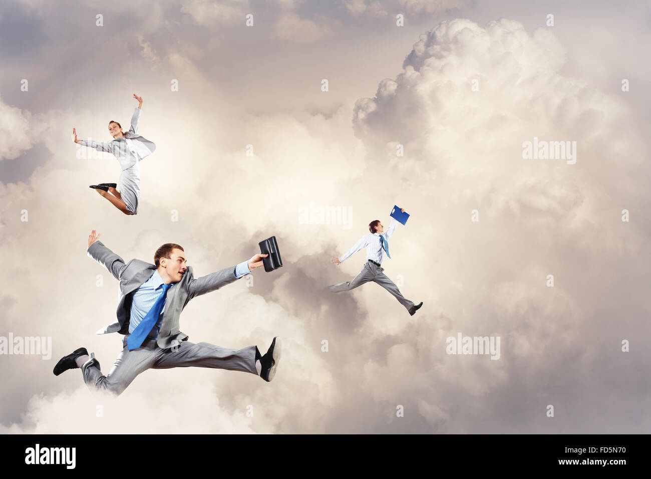 Image of happy business people jumping high in sky Stock Photo - Alamy