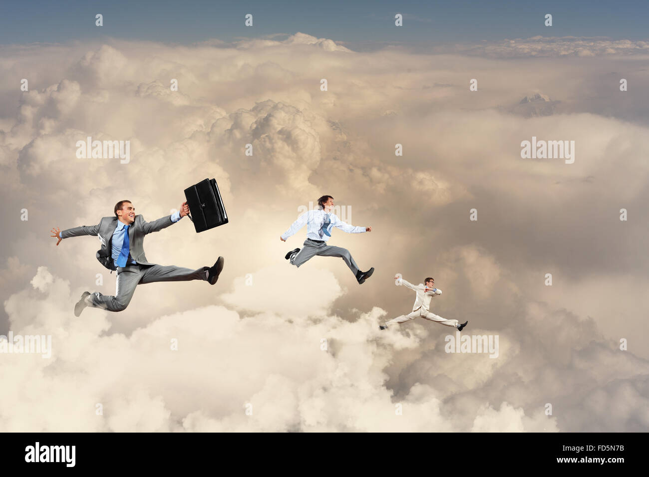 Image of happy business people jumping high in sky Stock Photo - Alamy