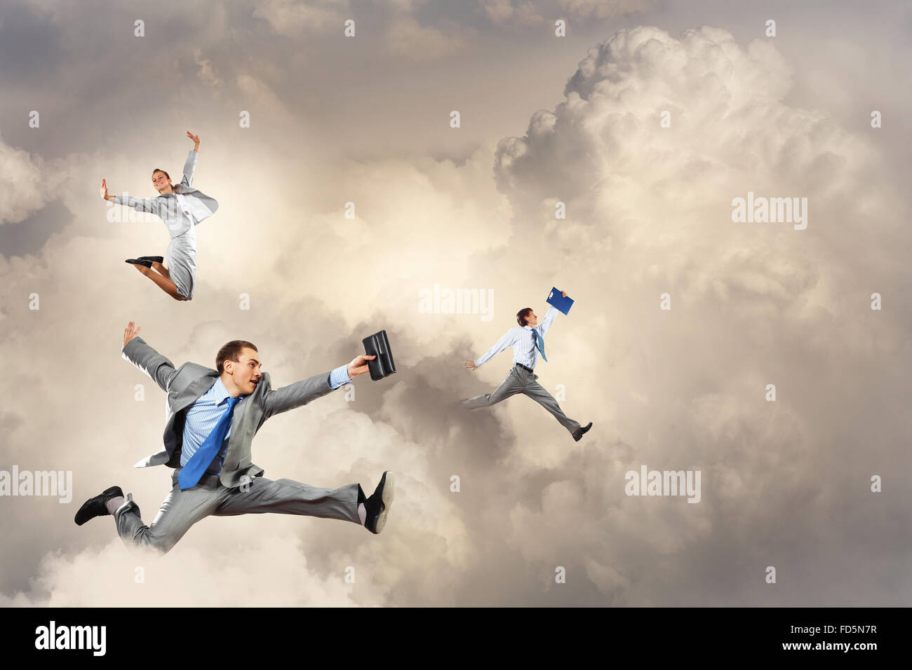 Image of happy business people jumping high in sky Stock Photo - Alamy