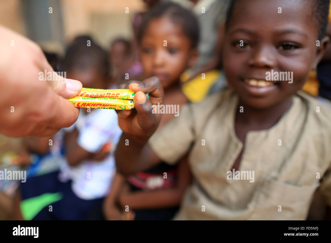 White tourist offering sweets to African children Stock Photo - Alamy