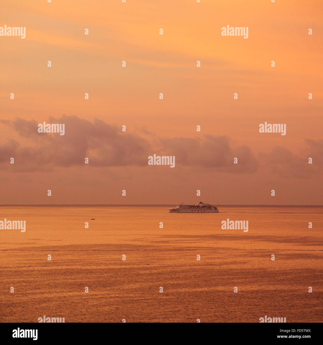 A ship on the Atlantic Ocean off Tenerife, Spain. Morning light gives ...