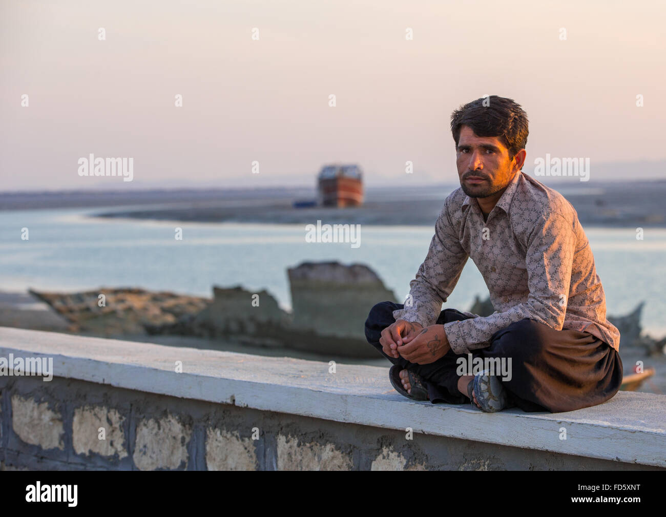 a man sitting by the sea, Qeshm Island, Laft, Iran Stock Photo - Alamy