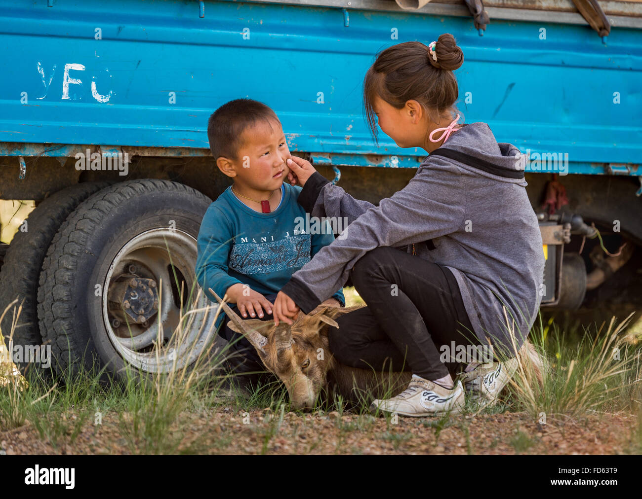 Big sister comforts her little brother as they watch over the family ...