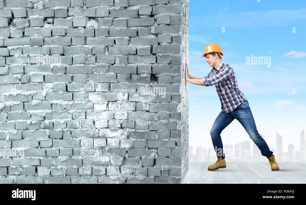Image of man engineer leaning on wall. Construction concept Stock Photo ...