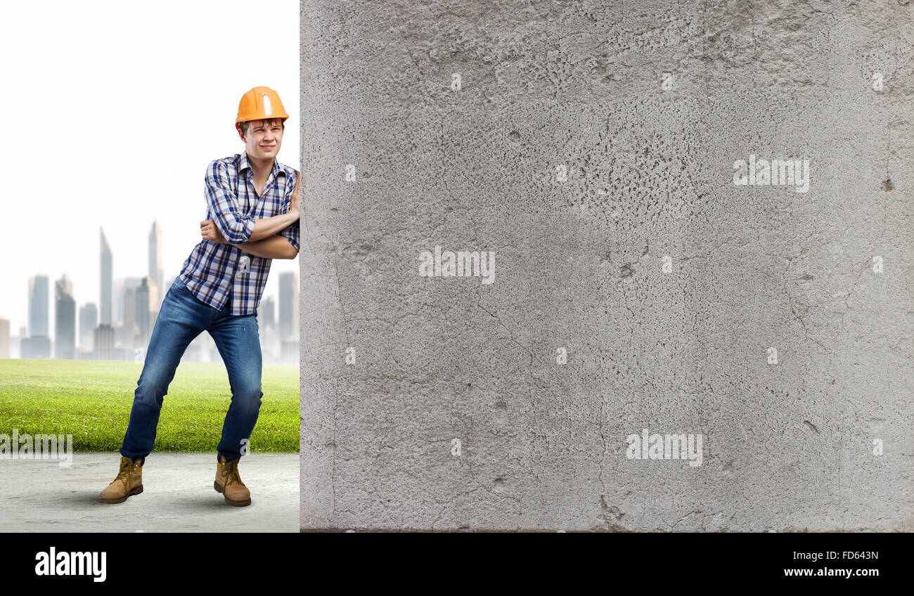 Image of man engineer leaning on wall. Construction concept Stock Photo ...