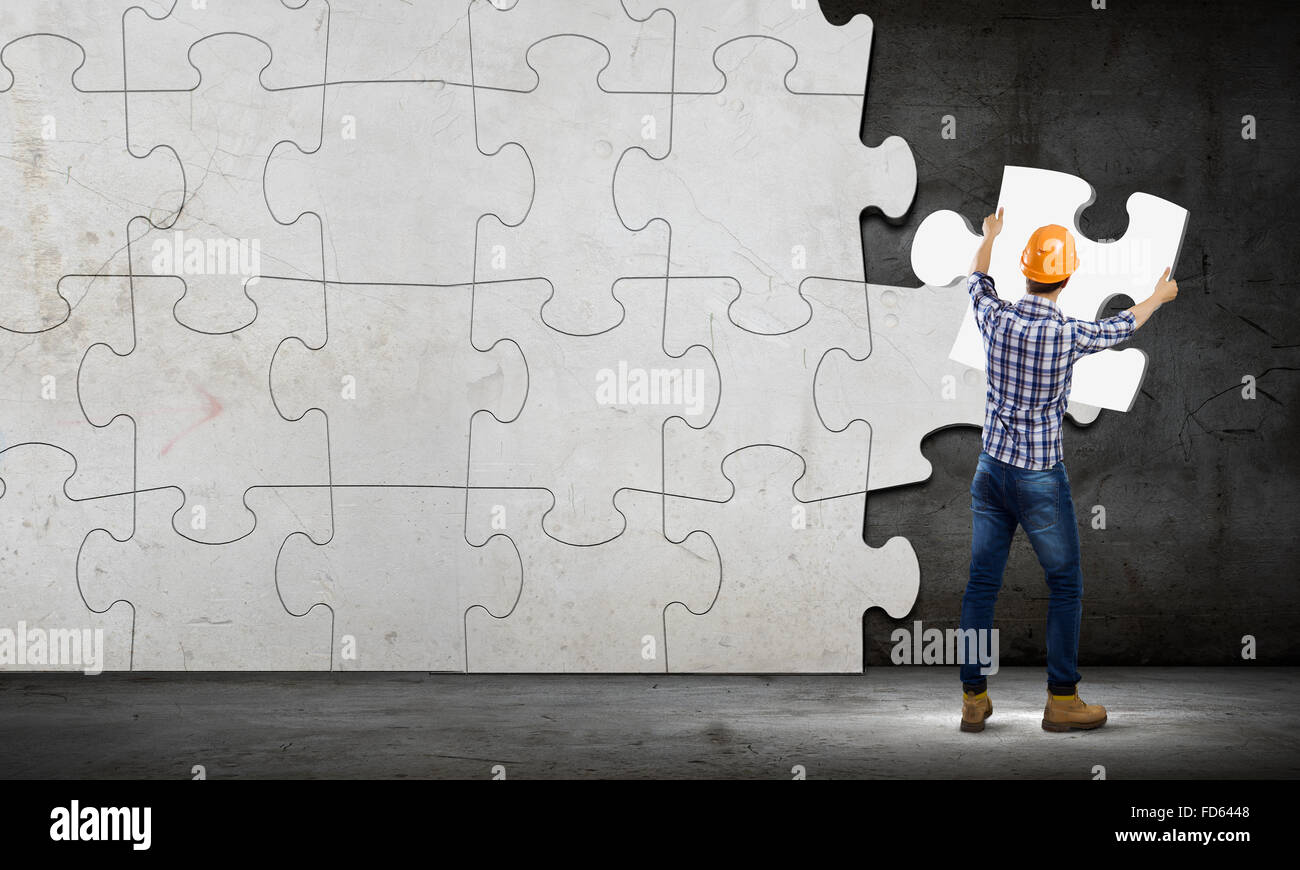 Image of man engineer connecting puzzle elements. Construction concept ...