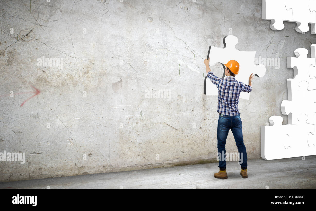 Image of man engineer connecting puzzle elements. Construction concept ...