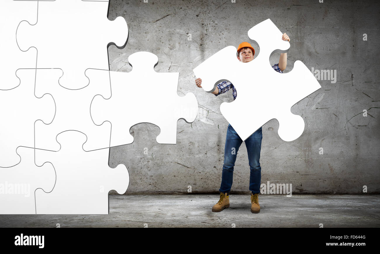 Image of man engineer connecting puzzle elements. Construction concept ...