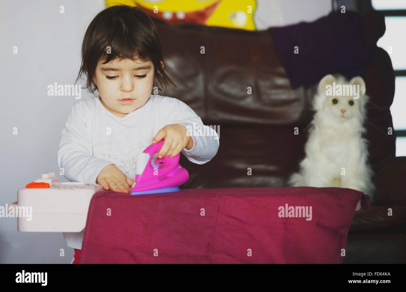little cute child ironing the clothes with iron toy Stock Photo - Alamy