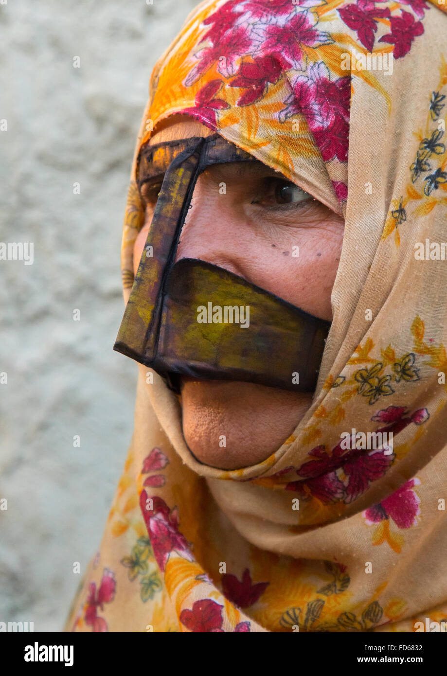 a bandari woman wearing a traditional mask called the burqa with a ...