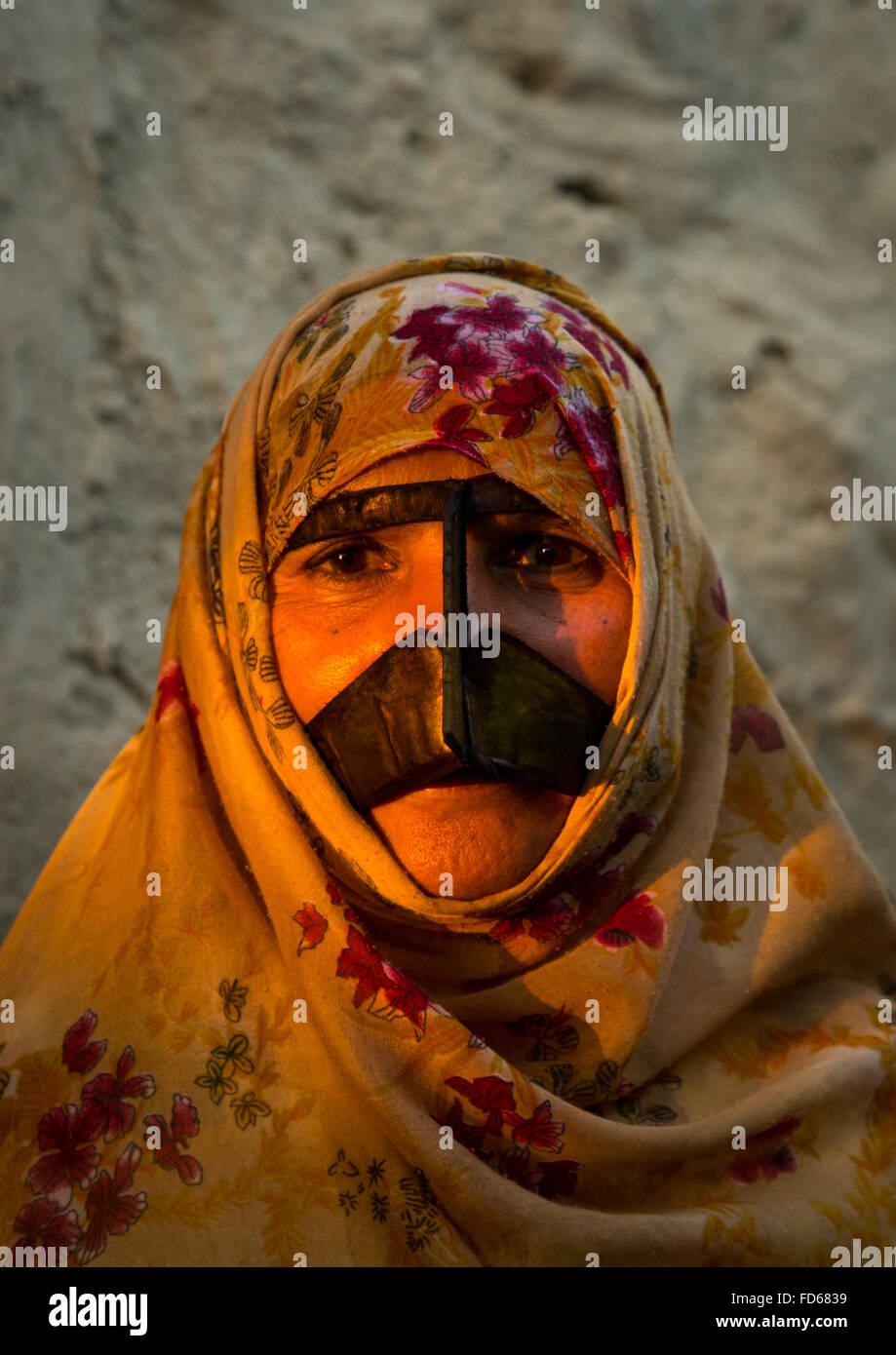 a bandari woman wearing a traditional mask called the burqa with a ...