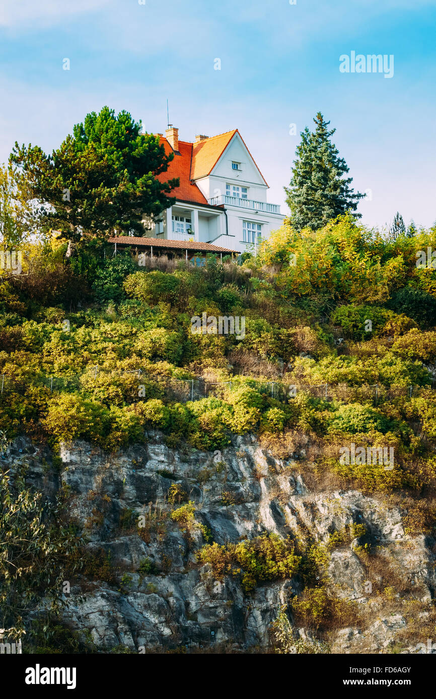 Wooden house cottage on top of cliff or rock, summer sunny evening ...