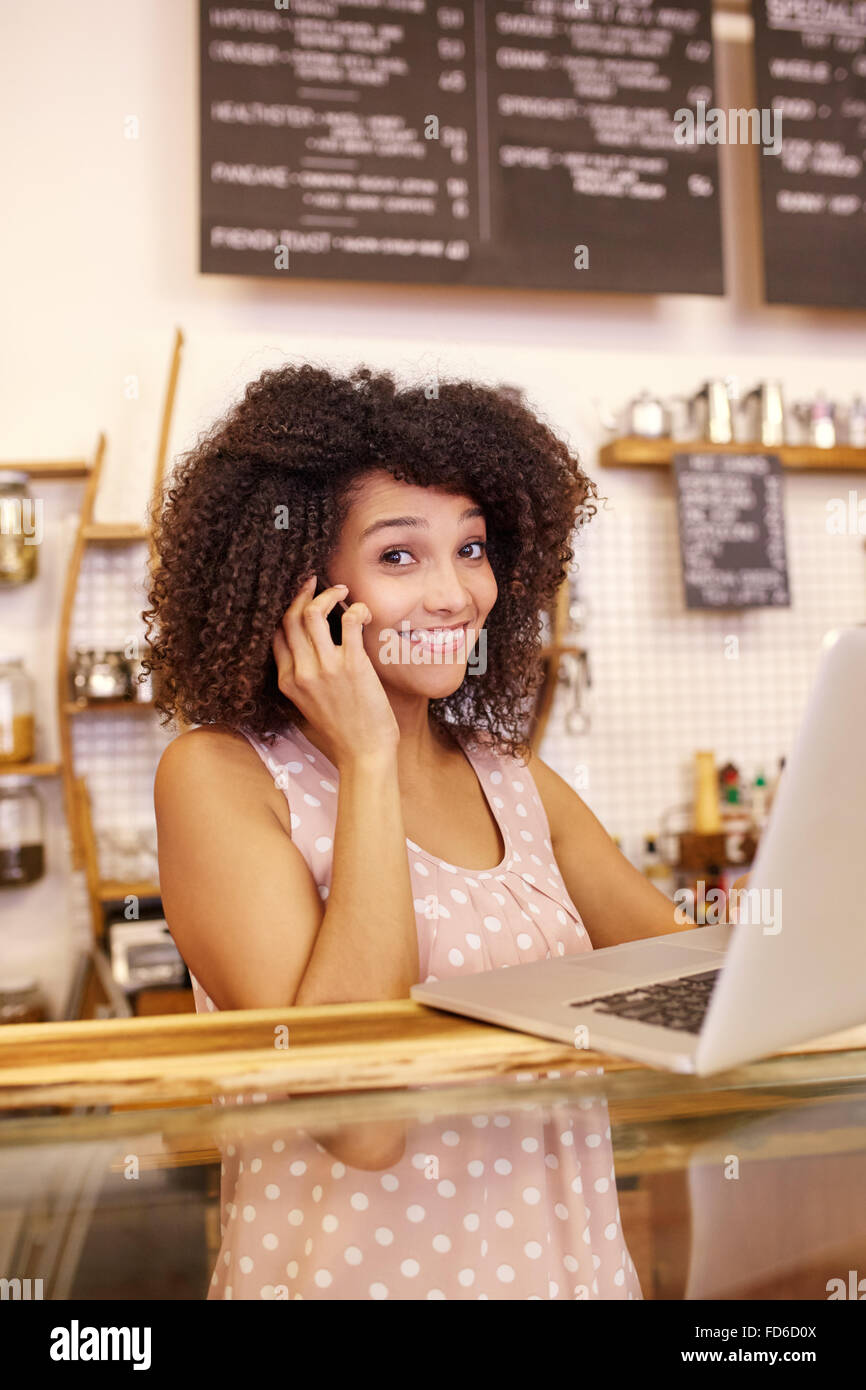 Woman looking up at you from behind her cafe counter Stock Photo - Alamy