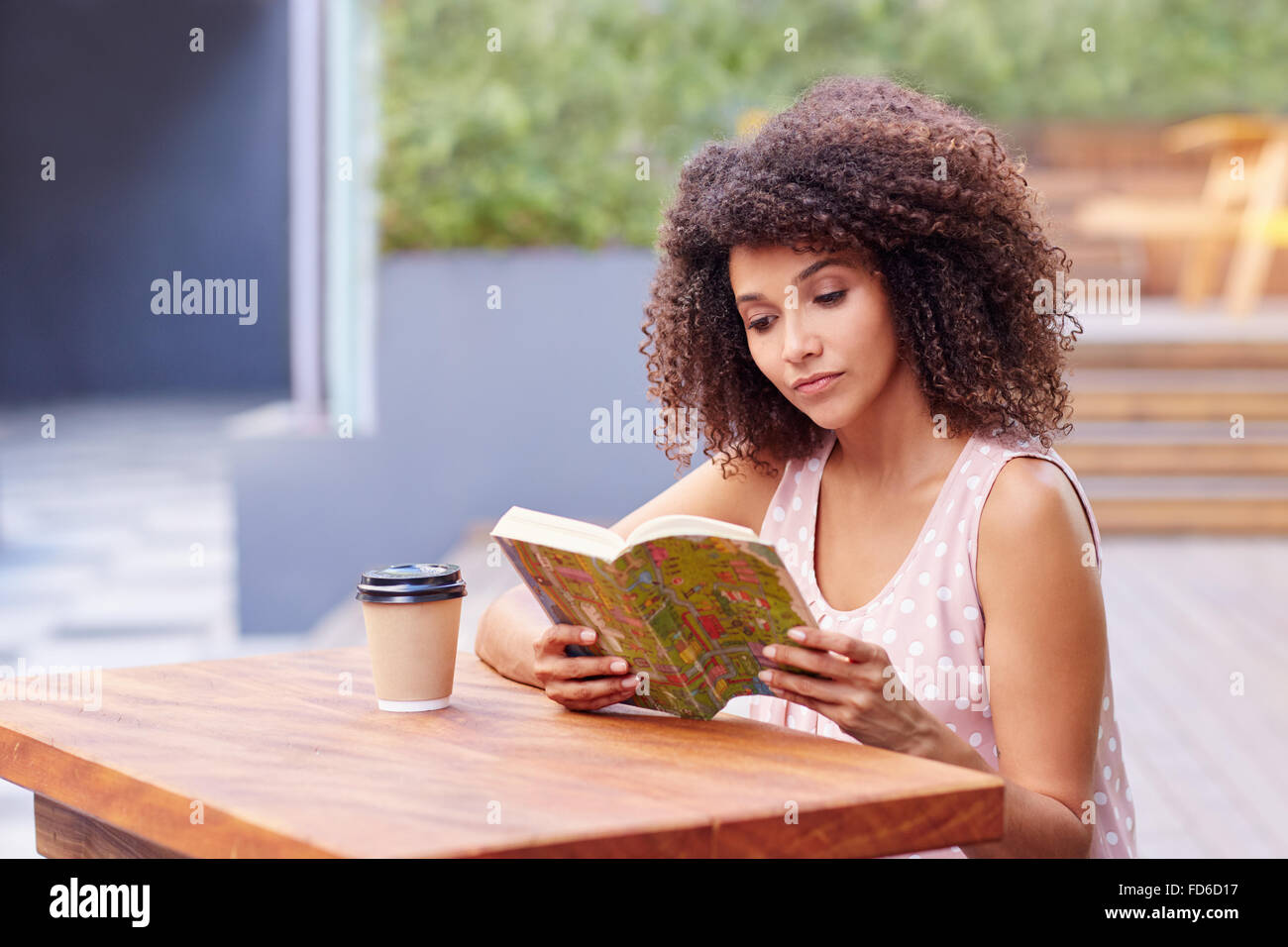 Young brunette reading book table hi-res stock photography and images ...