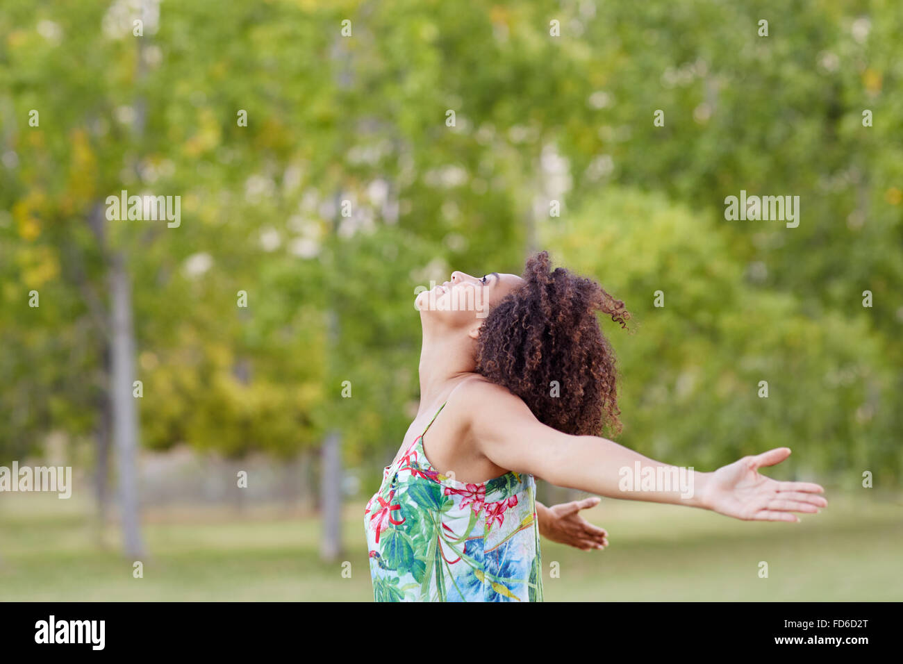 Woman stretching arms out behind her in a green park Stock Photo - Alamy
