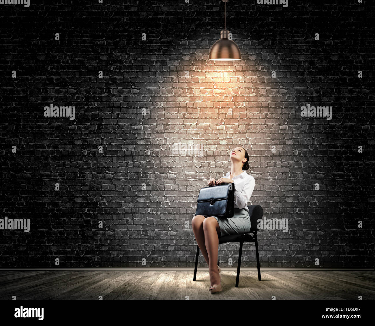 Image of young businesswoman sitting on chair under spot of light Stock ...