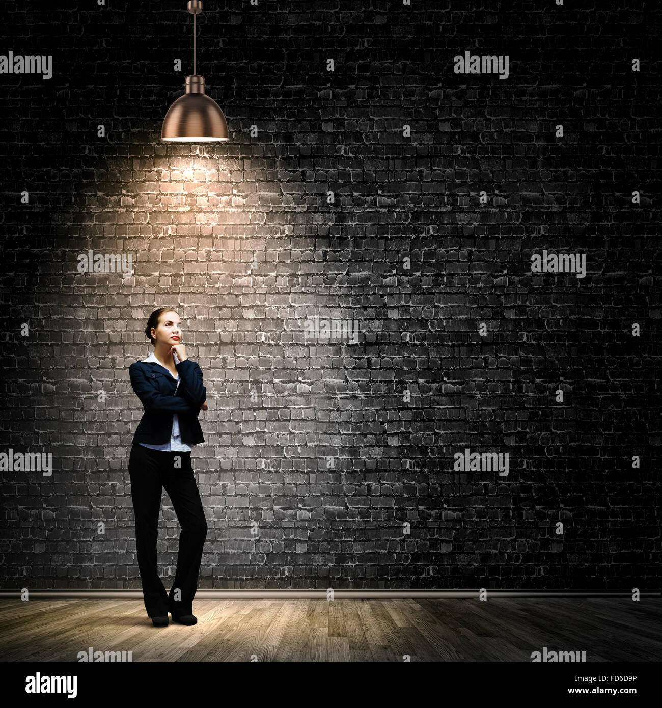 Image of young businesswoman standing under spot of light Stock Photo ...