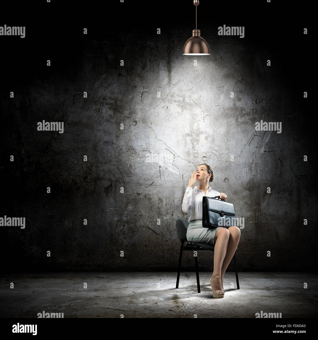 Image of young businesswoman sitting on chair under spot of light Stock ...