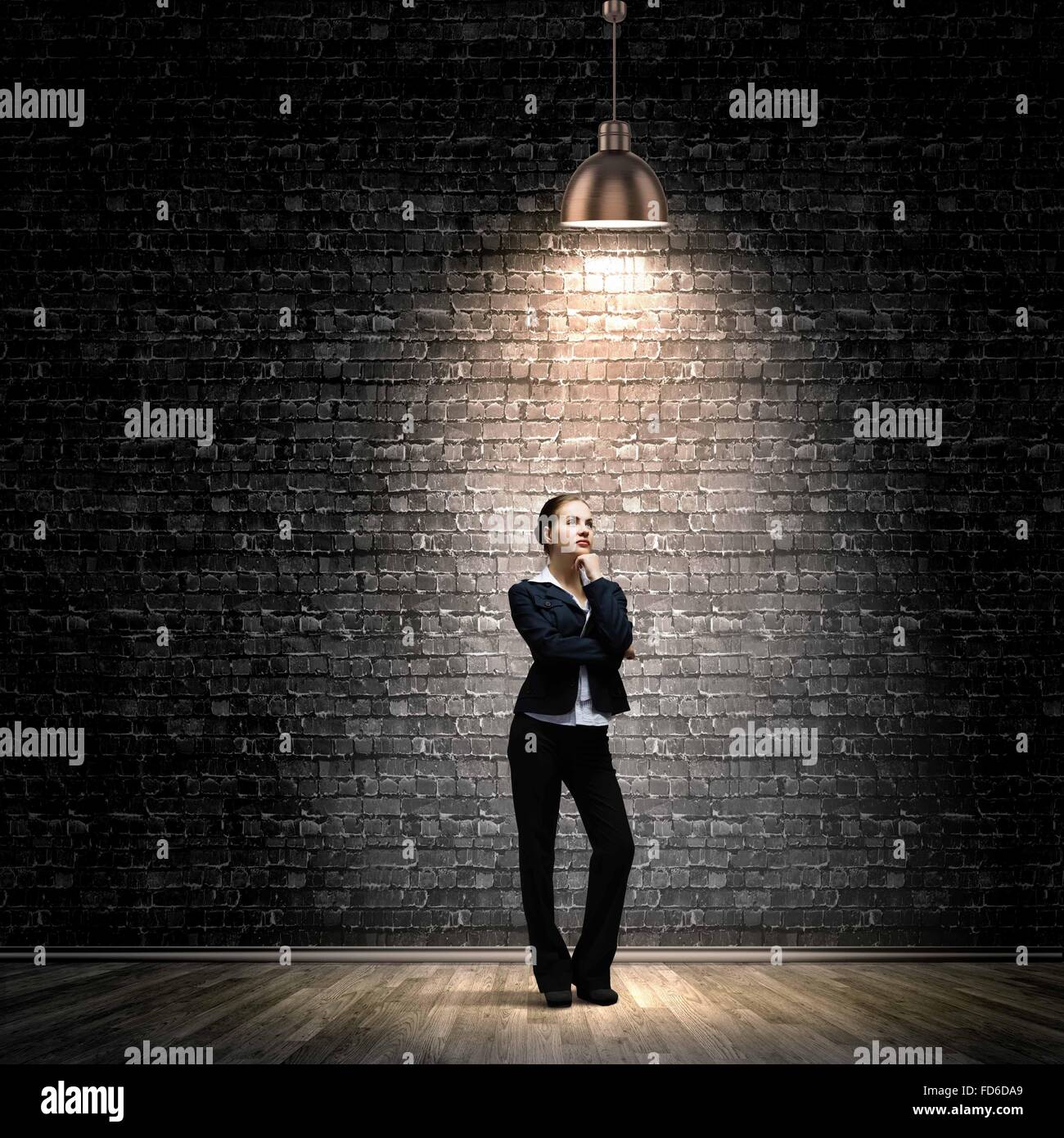 Image of young businesswoman standing under spot of light Stock Photo ...