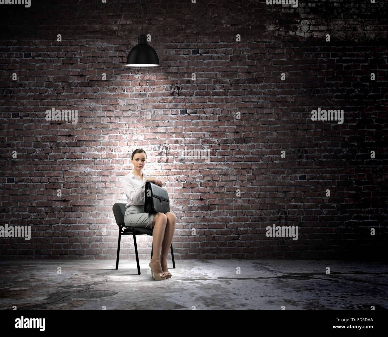 Image of young businesswoman sitting on chair under spot of light Stock ...