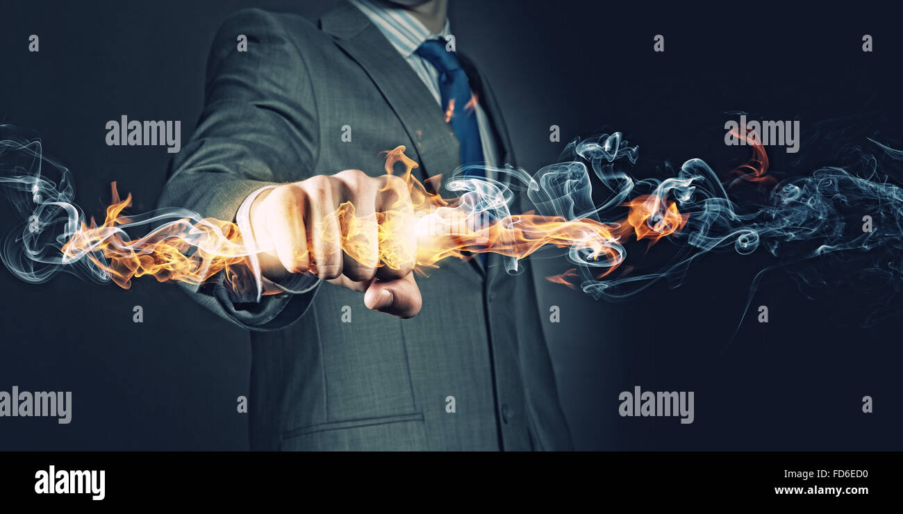 Businessman holding fire flames in fist. Power and control Stock Photo ...