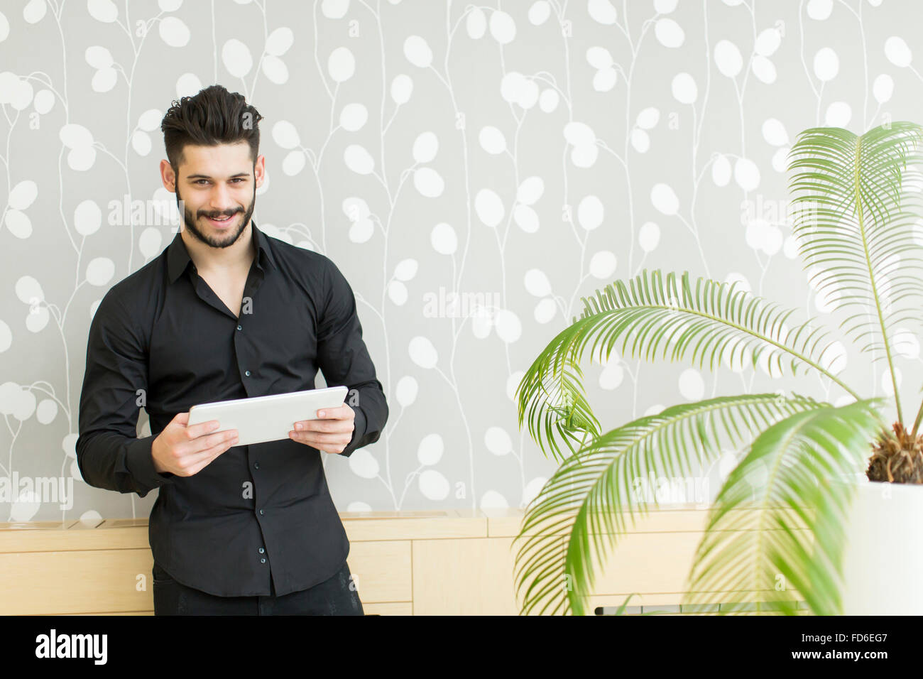 Man with tablet by the wall Stock Photo - Alamy