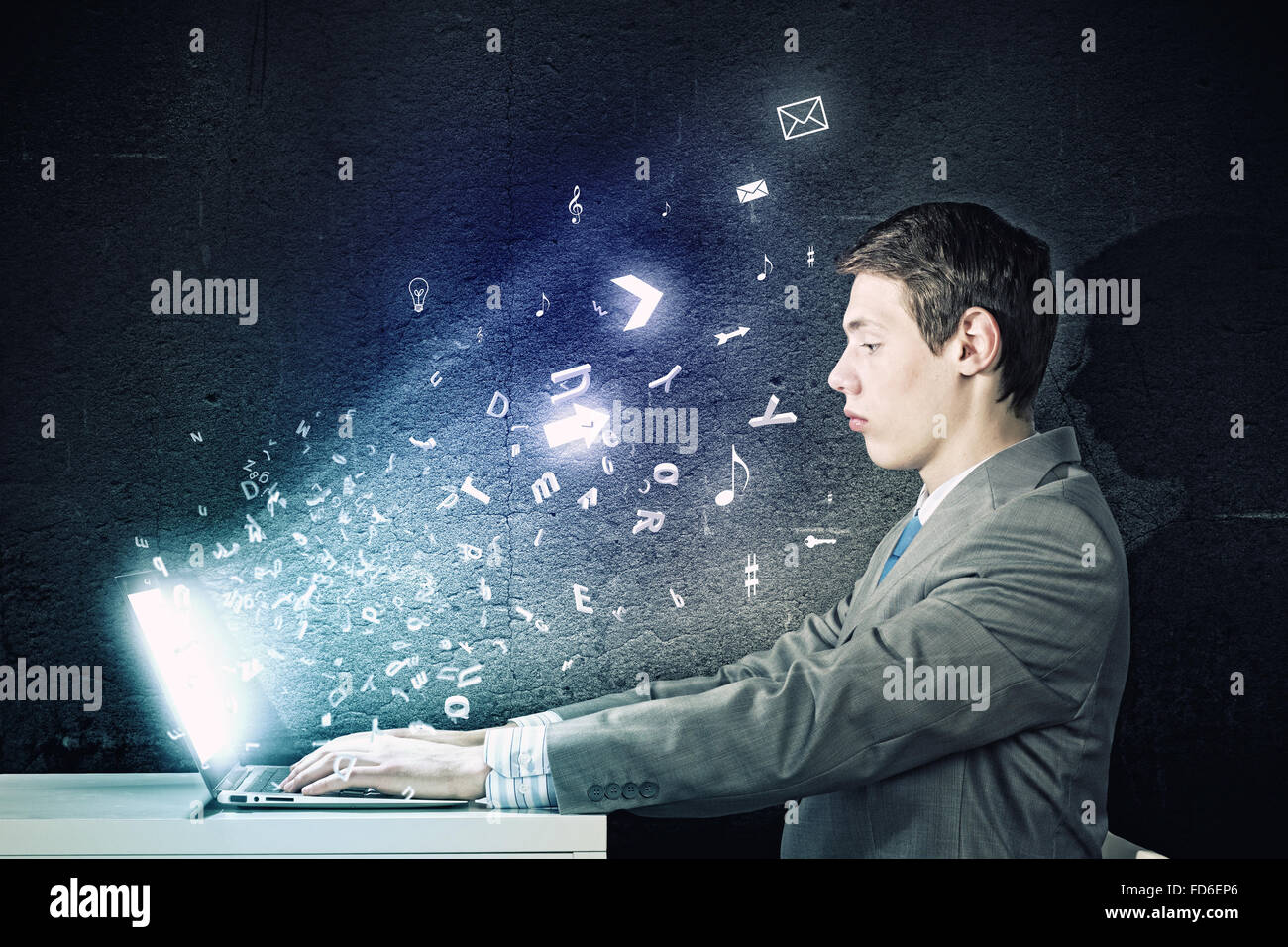 Thoughtful young man in suit seriously looking in laptop Stock Photo ...