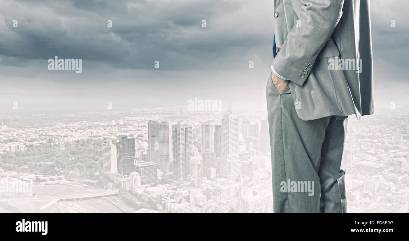Bottom view of businessman against city background Stock Photo - Alamy