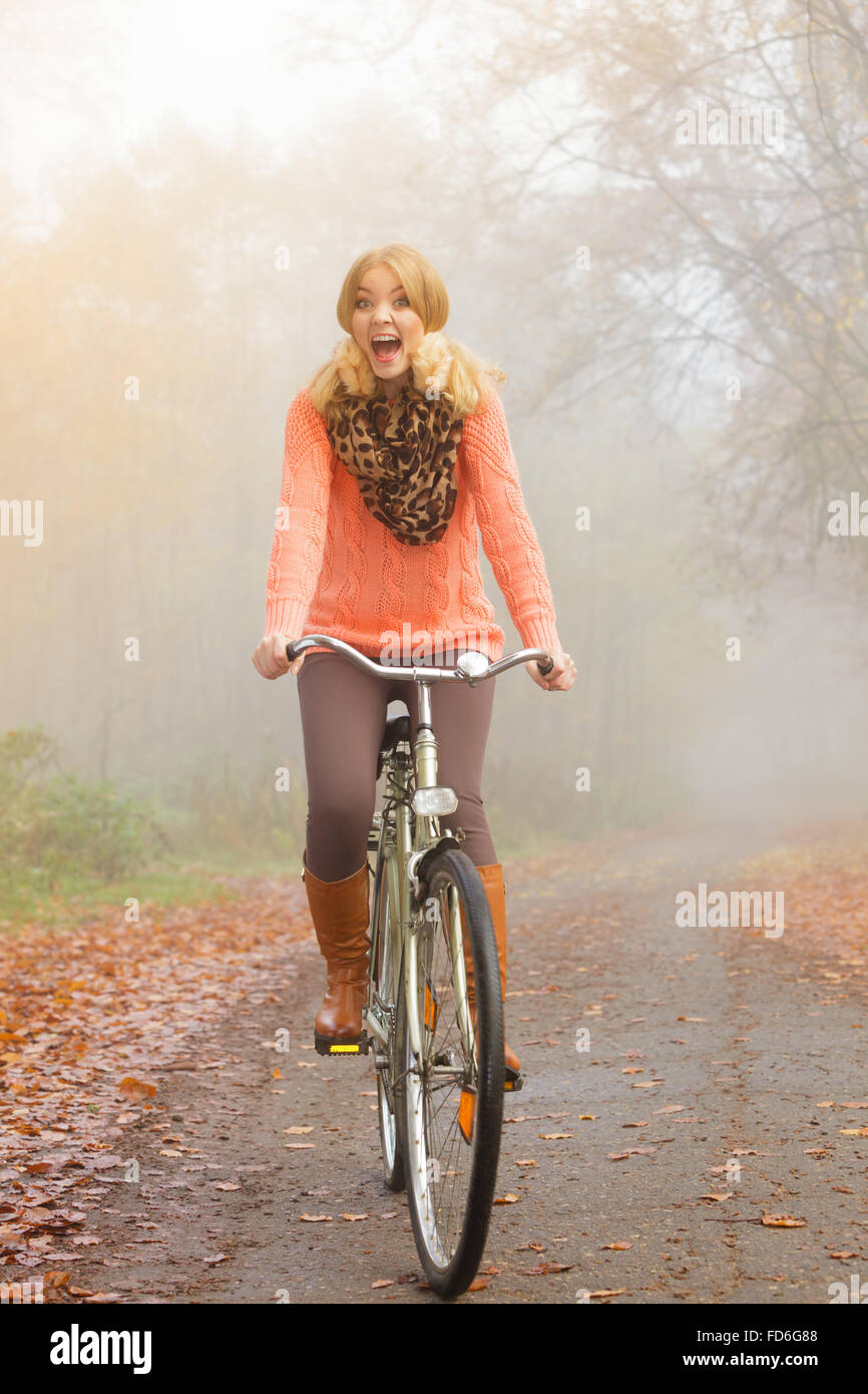 Happy active woman riding bike bicycle in fall autumn park. Glad young ...
