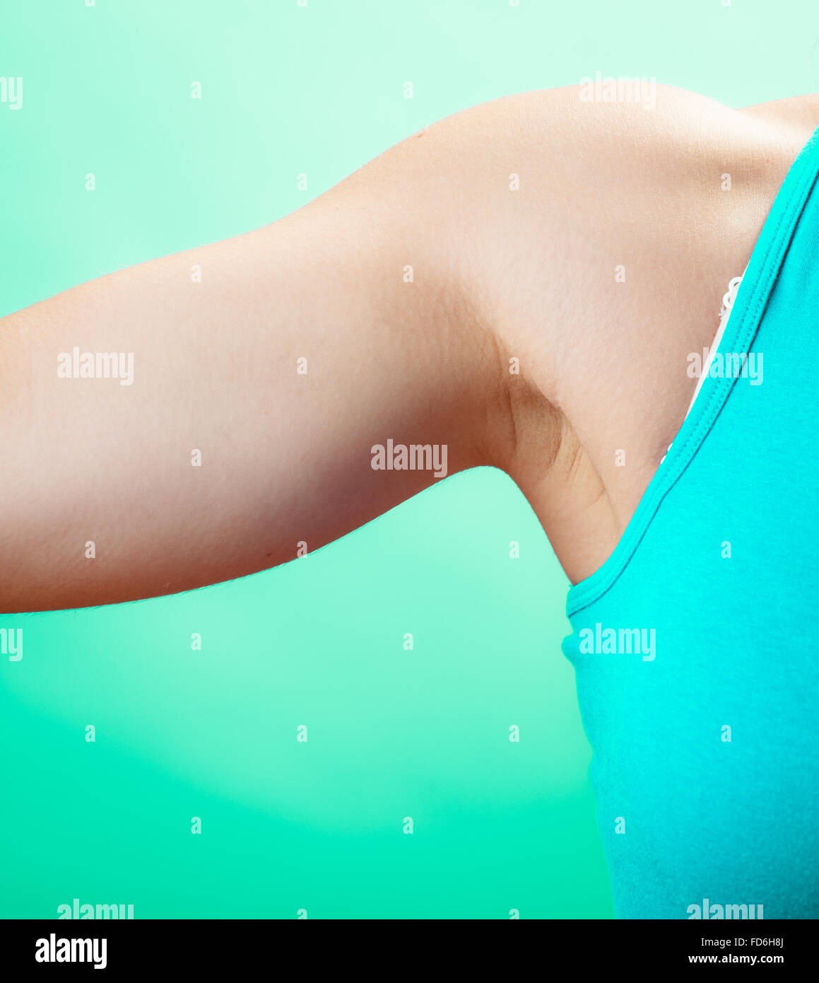 Fit slim woman body concept. Female arm on blue green background in ...