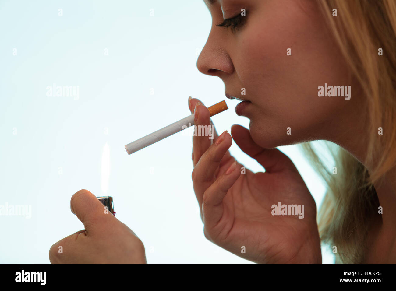 Pretty girl smoking cigarette using lighter. Addicted nicotine problems ...