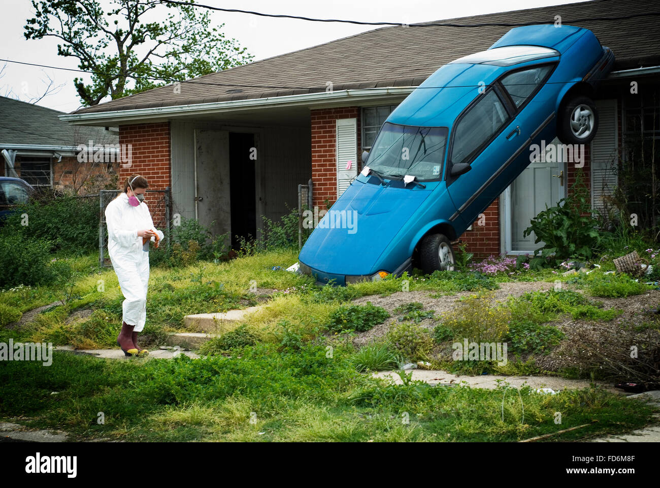 Volunteers in full protective gear strip heavily molded drywall and ...