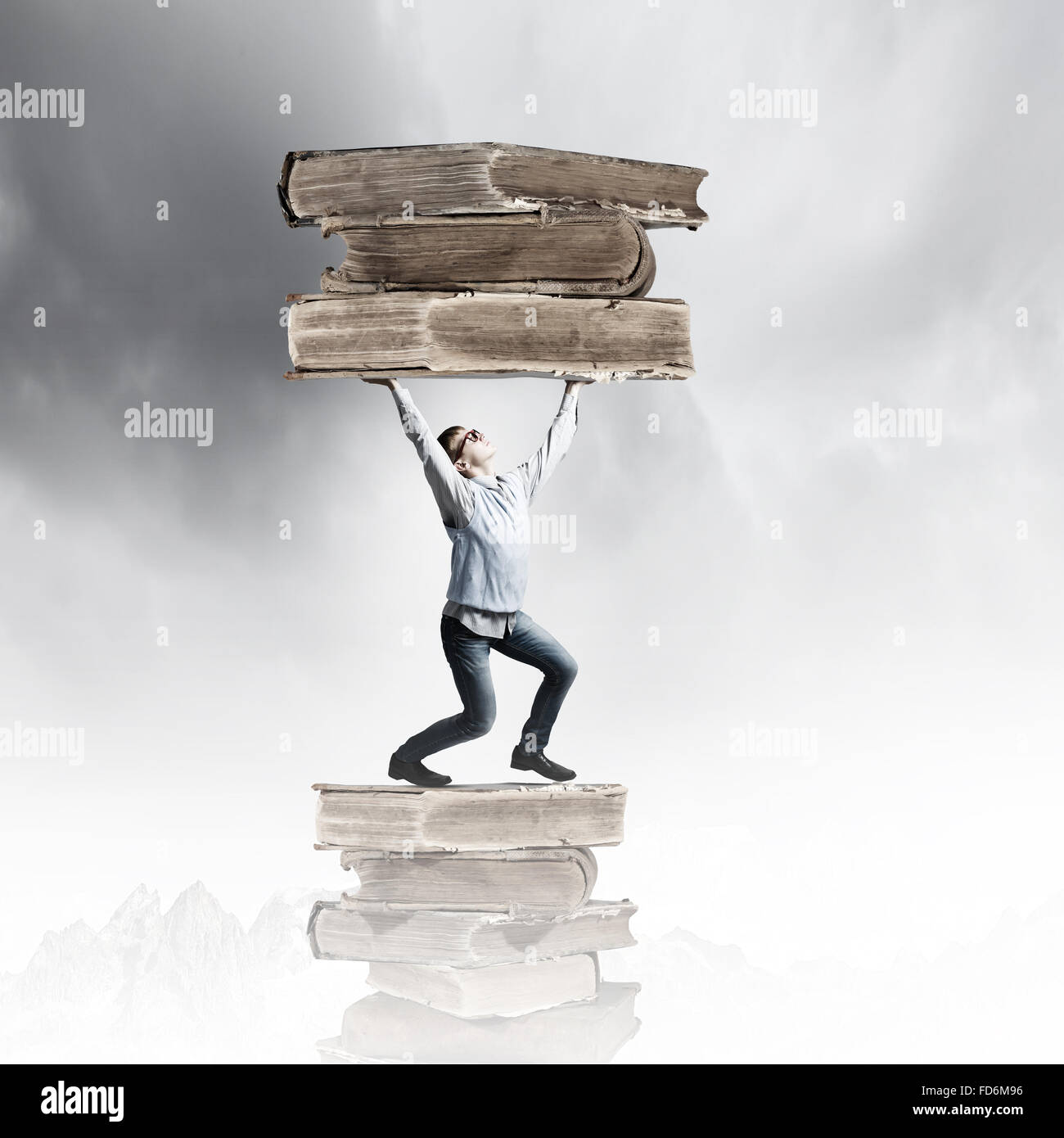 Young man holding huge book above head Stock Photo - Alamy