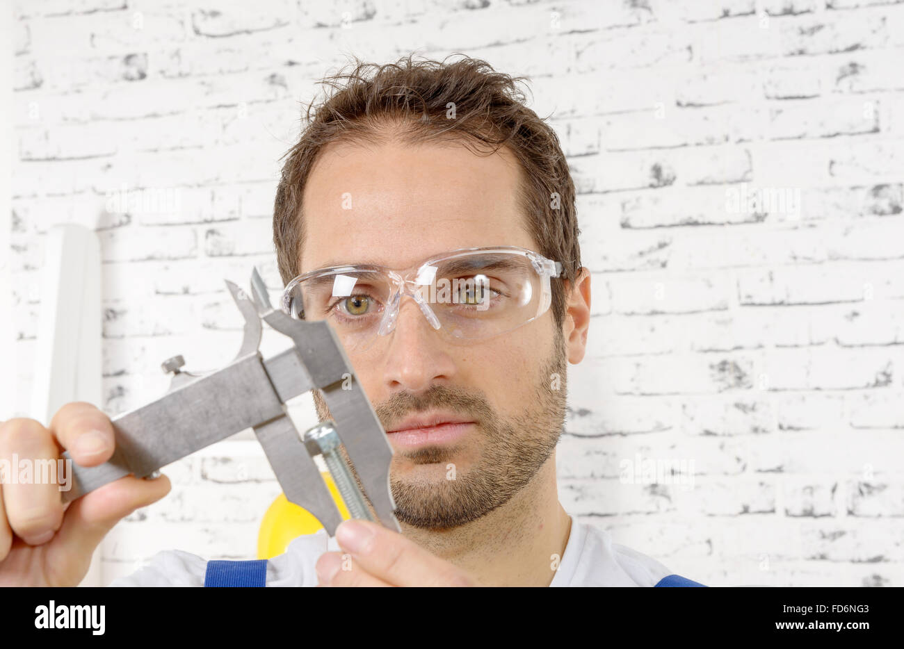 a young man measuring screw using caliper Stock Photo - Alamy