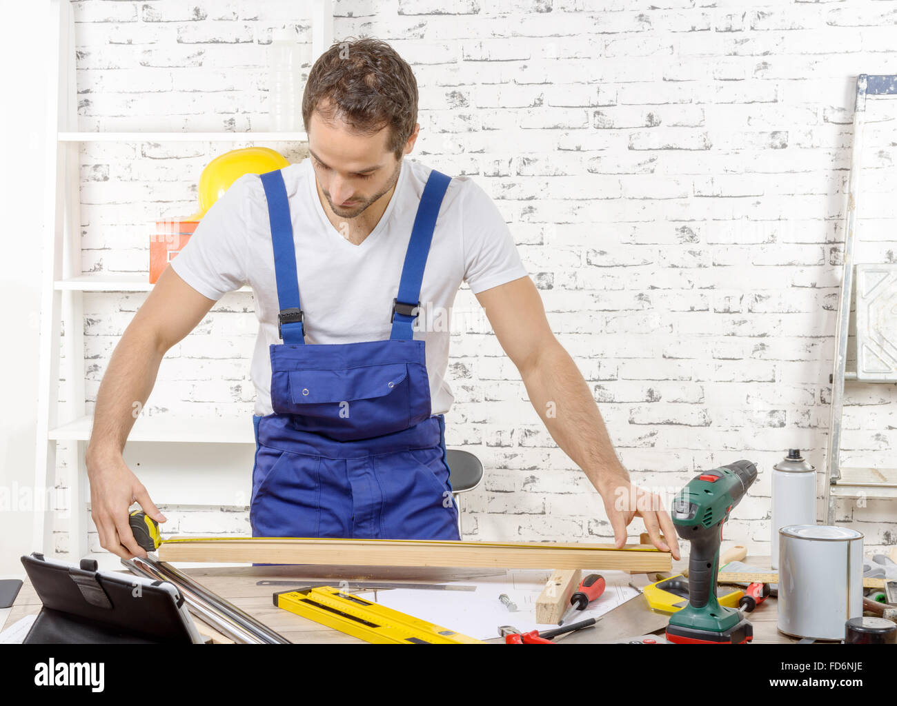 a young man measuring wooden board Stock Photo - Alamy
